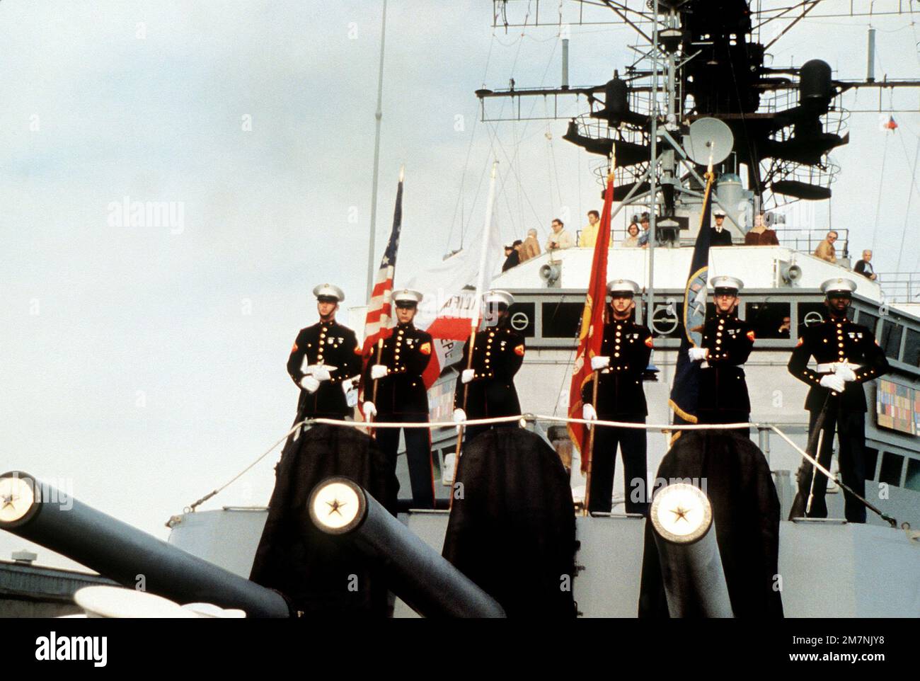 A Marine honor guard stands atop the triple Mark 16 6-inch/47-caliber ...