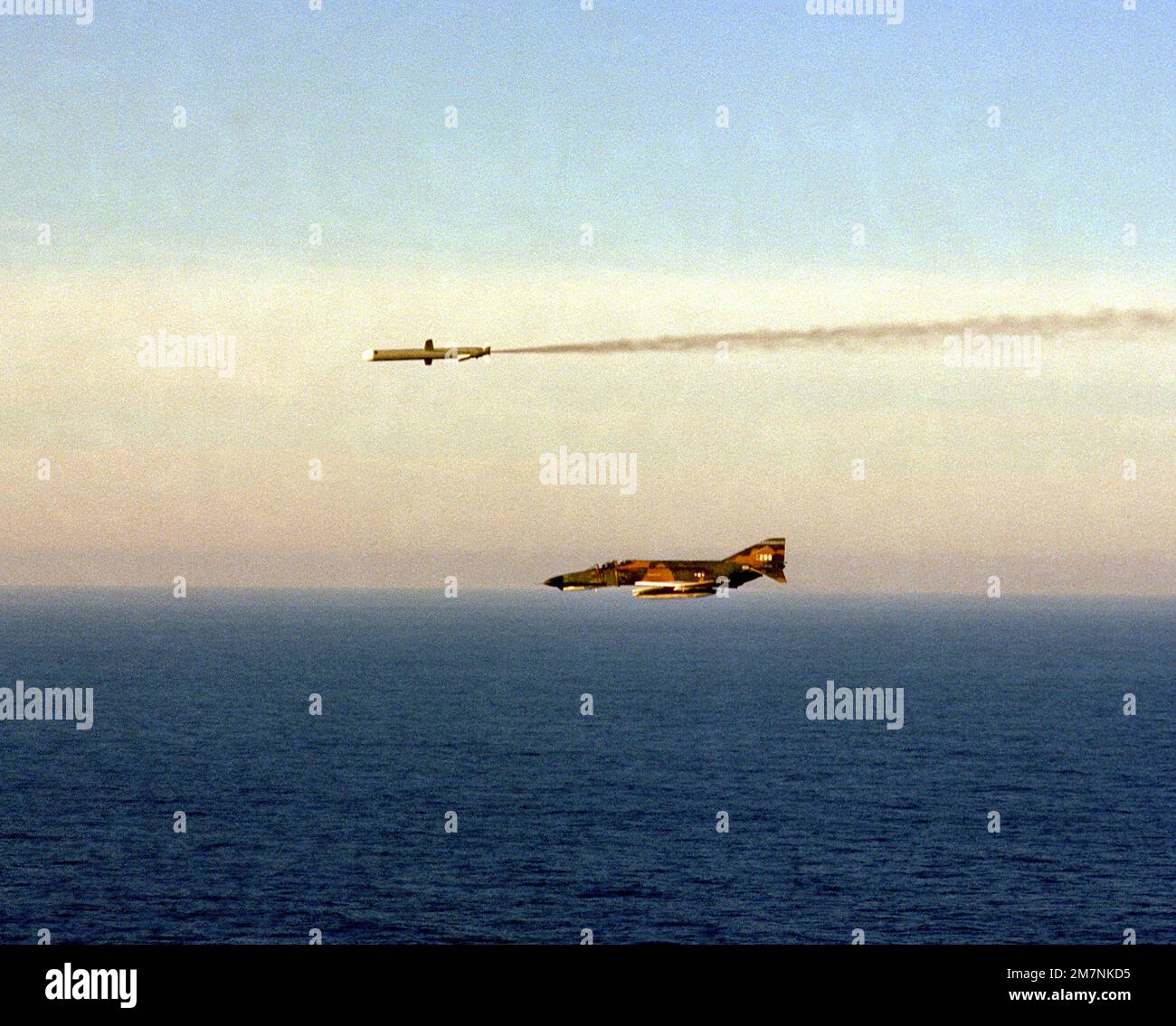 An AGM-109 Tomahawk cruise missile passes a photo chase F-4 Phantom II ...
