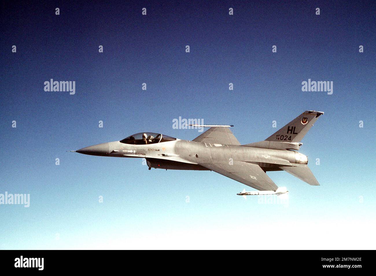 AN air-to-air left side view of an F-16 Fighting Falcon aircraft armed ...