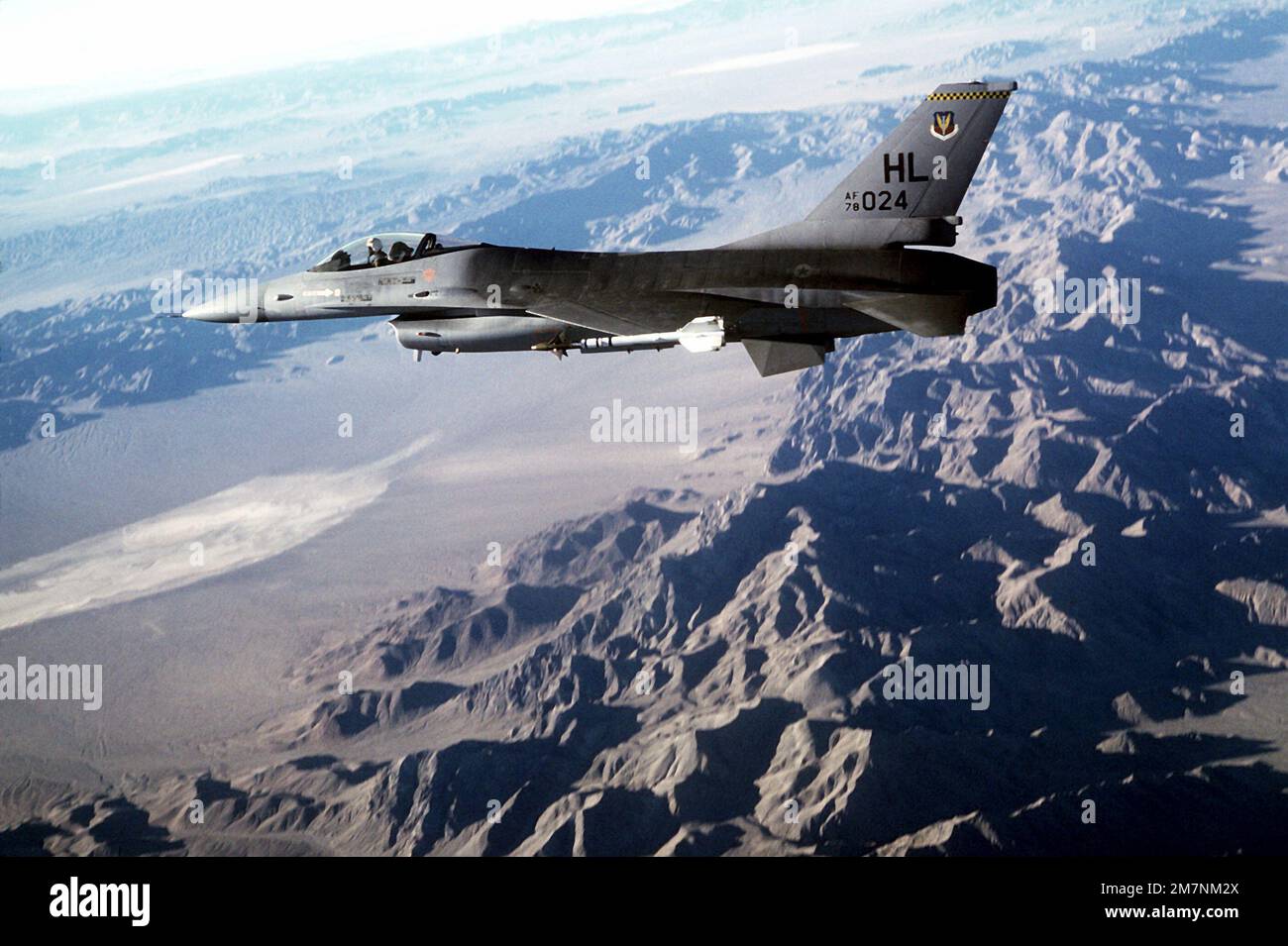 Air-to-air left side view of an F-16 Fighting Falcon aircraft armed ...