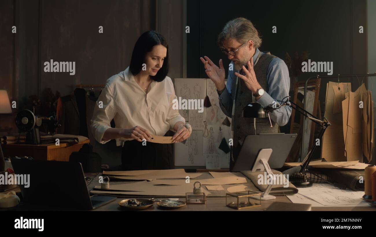 Tailors working with patterns for future clothes in luxury designer ...