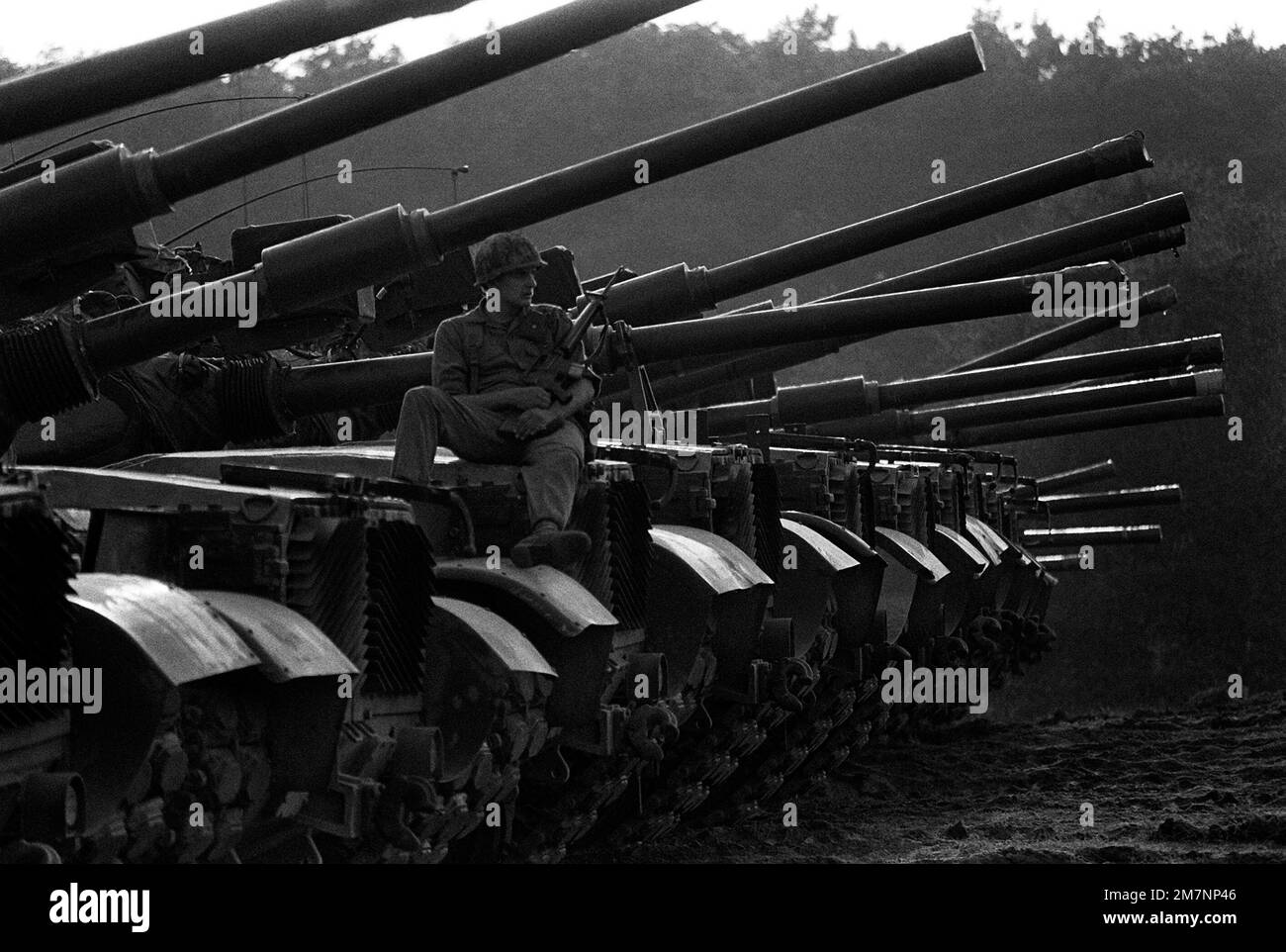 A soldier guards M-0A1 full-tracked combat tanks. Country: Unknown ...