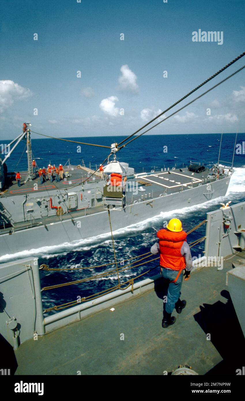 A sailor swing, out over the water, in a boatswains chair, during a ...