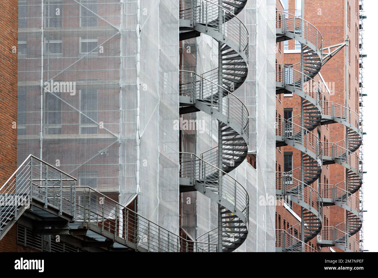 Several spiral staircases run along the outer wall of the building, and ...