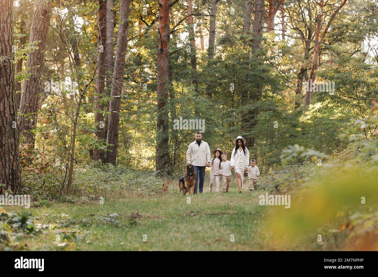 Happy playful family runing in park with pet. Young mom, dad having fun ...