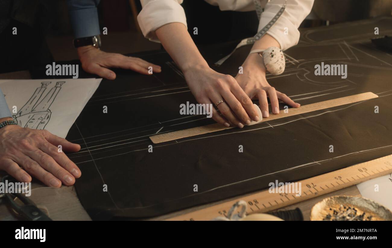 Male and female tailors transfer the sketch of future clothes to the ...