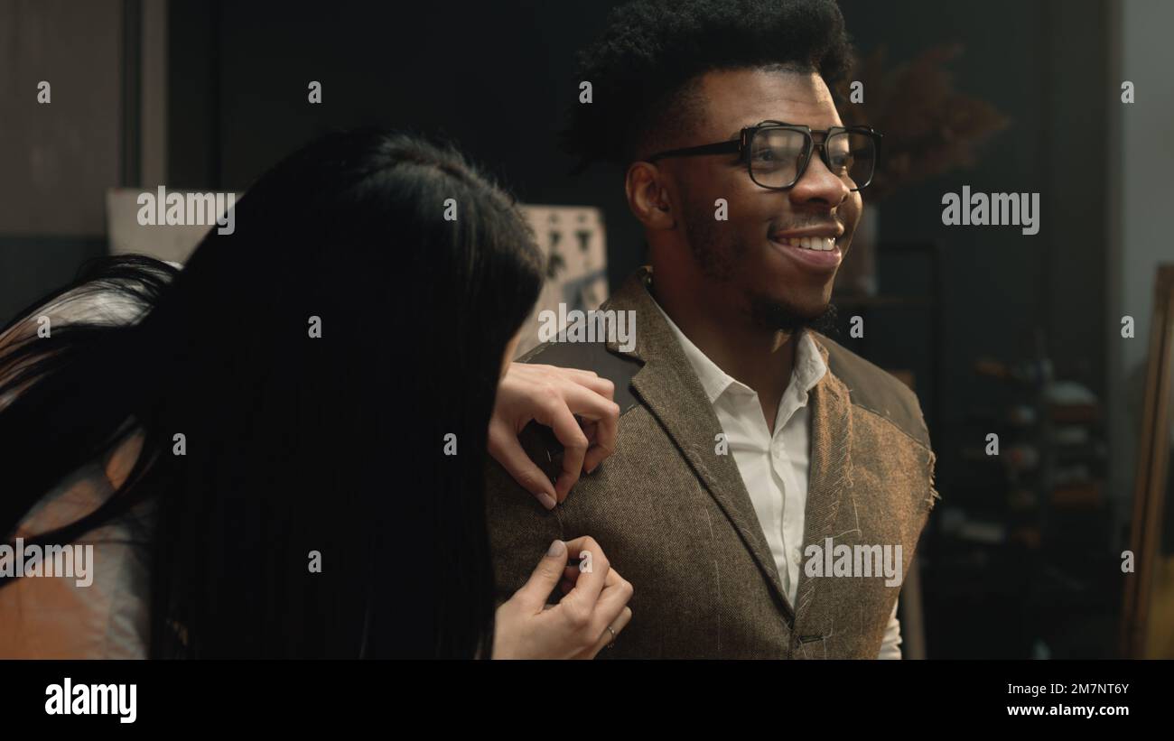 Female tailor measures tailored suit, discusses with client size and ...