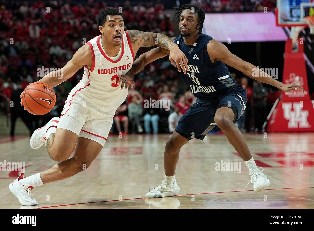 Houston guard Ramon Walker Jr. drives around North Florida guard Jarius ...