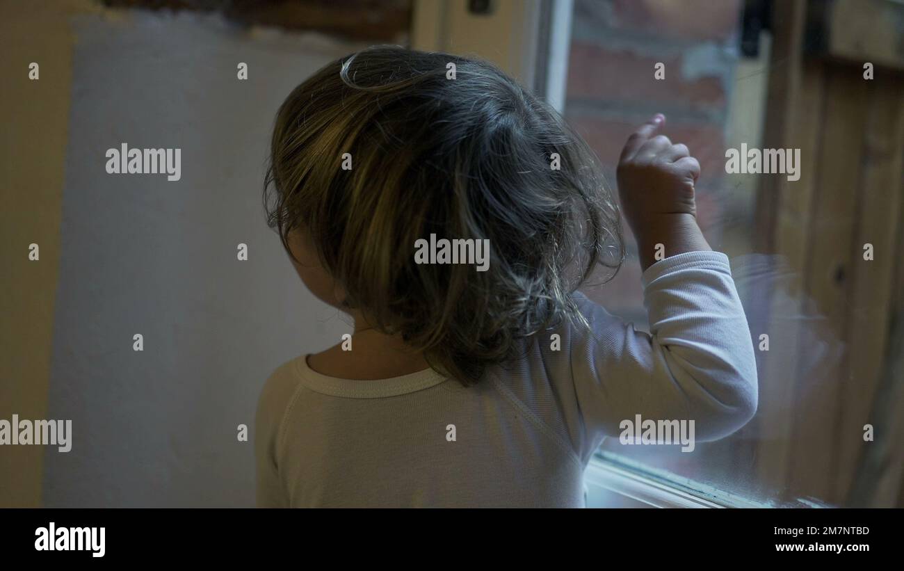 Child boy standing by window pointing at something outside Stock Photo ...