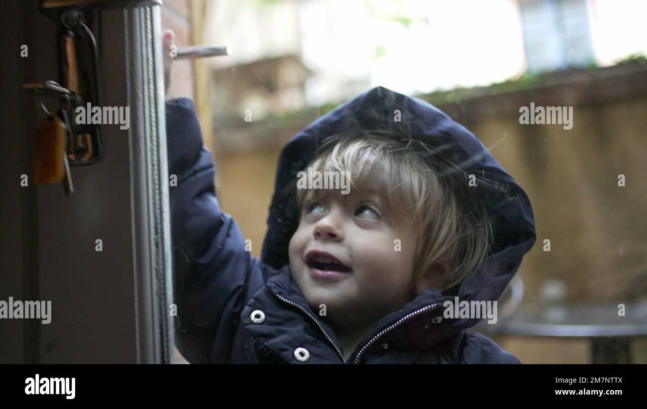 Cute baby toddler opening door, child opens doorknob entering house ...