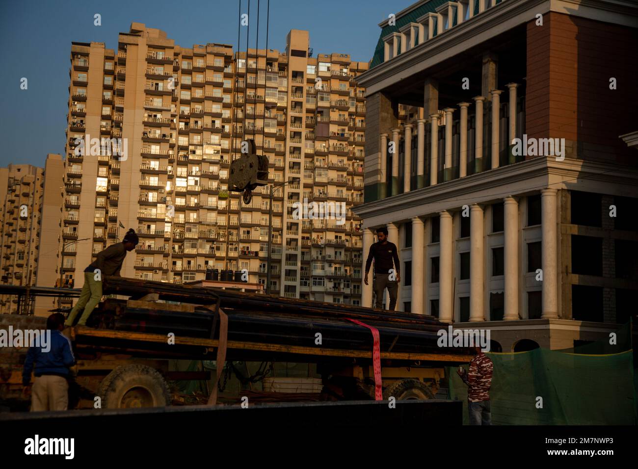 Workers handle building construction material in Greater Noida, India, Wednesday, Dec.7, 2022 ...
