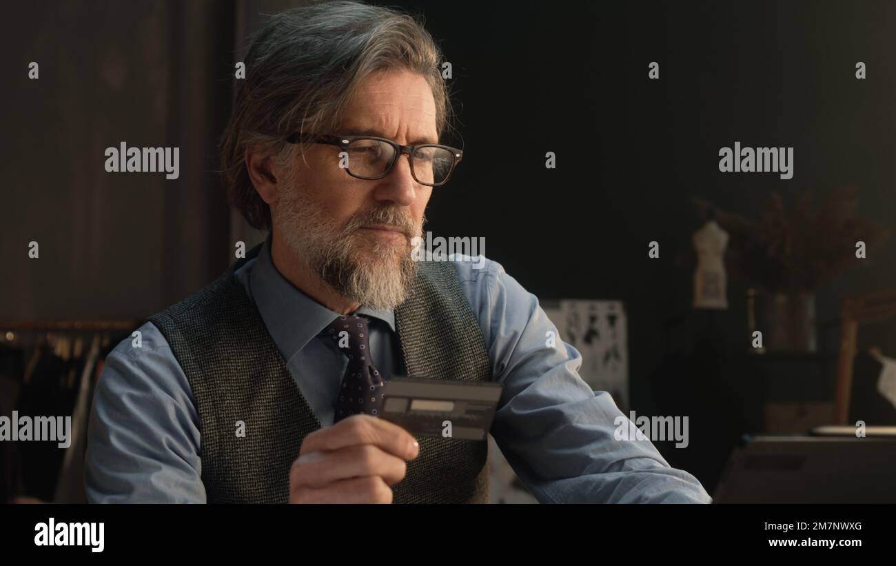 Tailor using tablet, transferring money on bank card, paying for ...