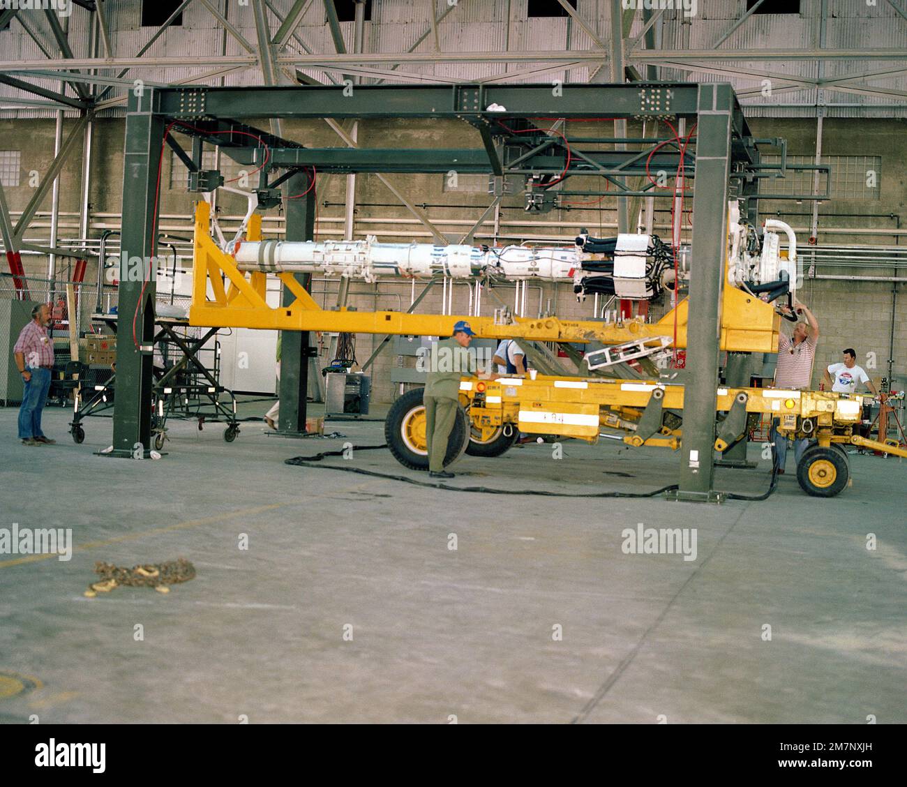 Technicians load an AGM-86 air launched cruise missile (ALCM) on a ...