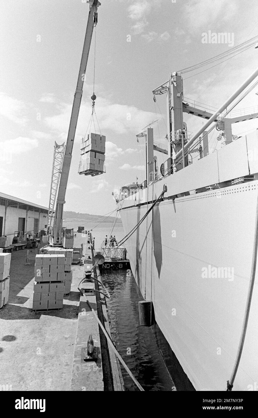 A pier-side crane is used to load supplies aboard the combat stores ...