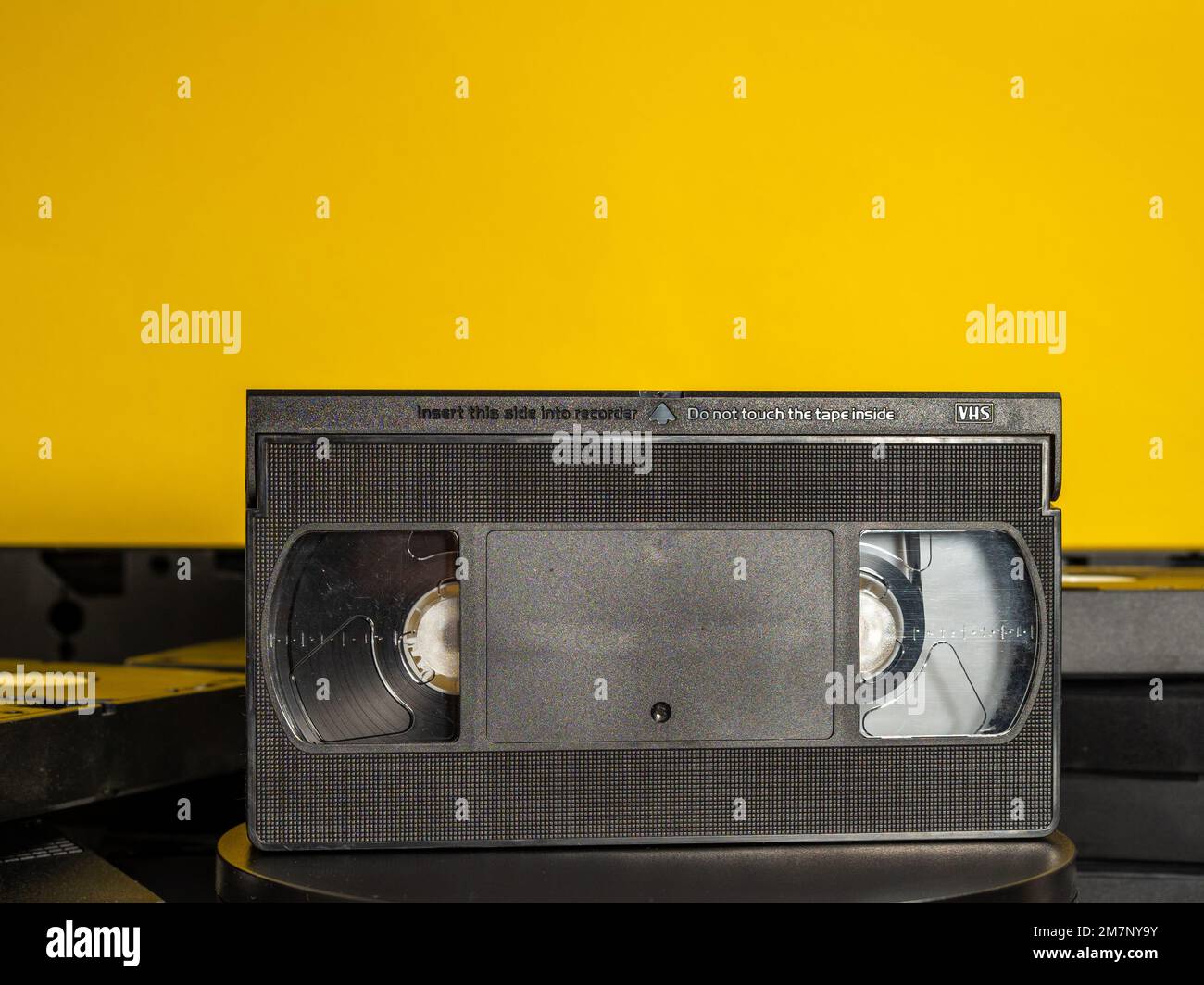 Old VHS cassettes on a yellow background. Retro video cassettes. Close ...