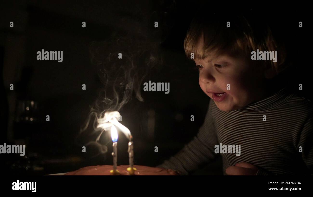 Cute child blowing birthday candles. Toddler boy celebrates anniversary ...
