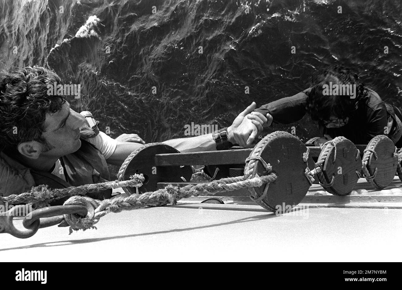 A crewman from the combat stores ship USS SAN JOSE (AFS-7) helps ...