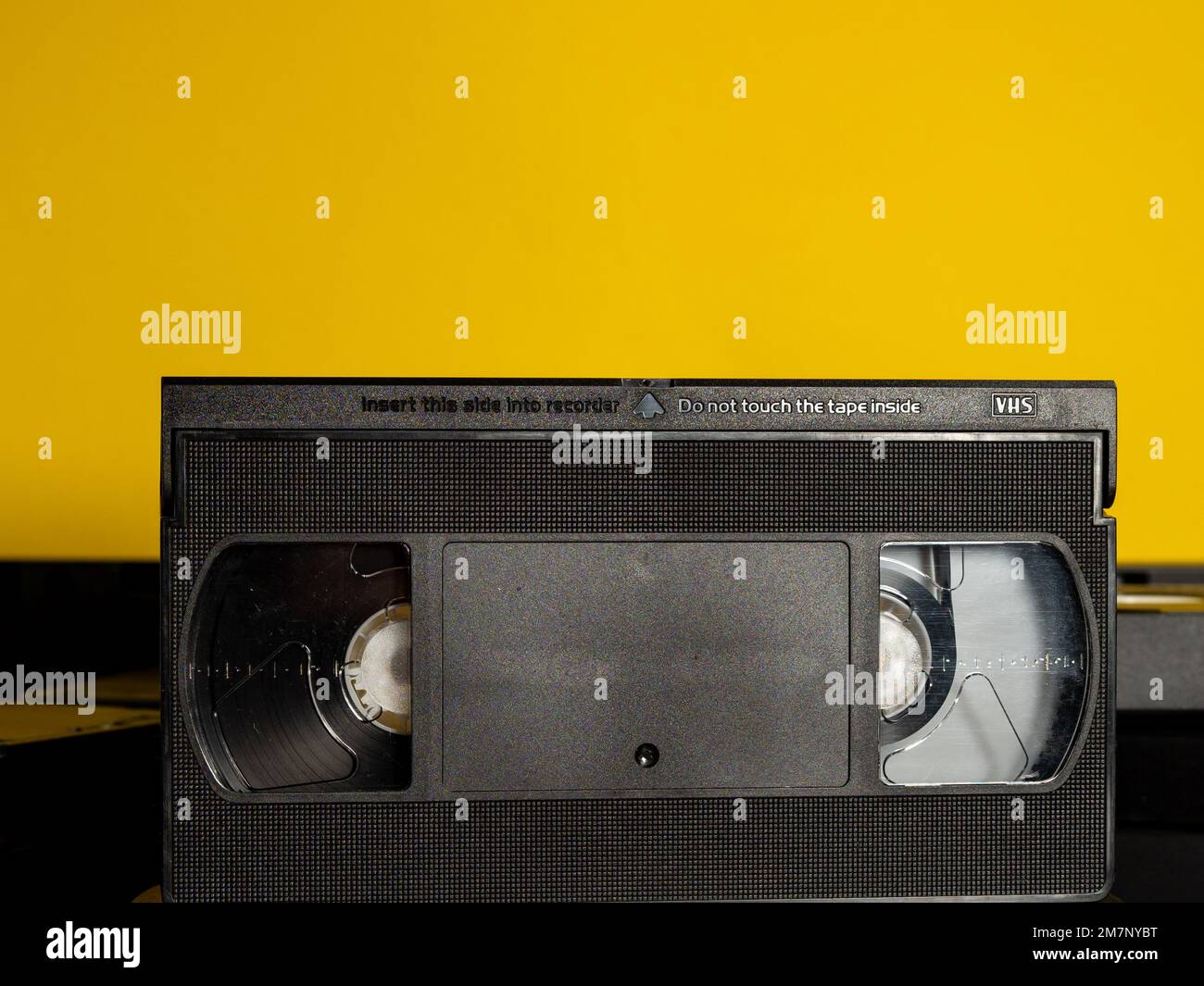 Old VHS cassettes on a yellow background. Retro video cassettes. Close ...