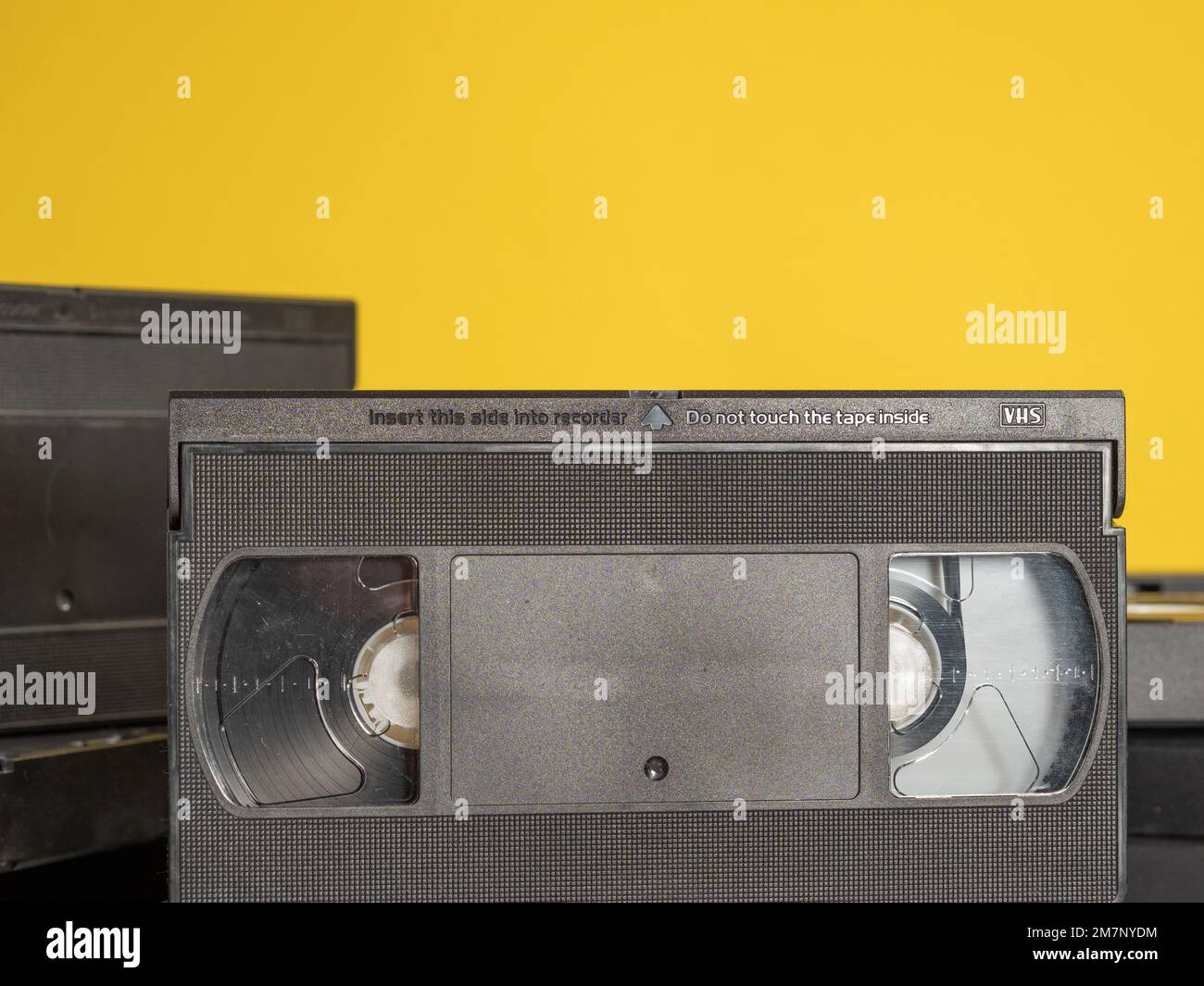 Old VHS cassettes on a yellow background. Retro video cassettes. Close ...
