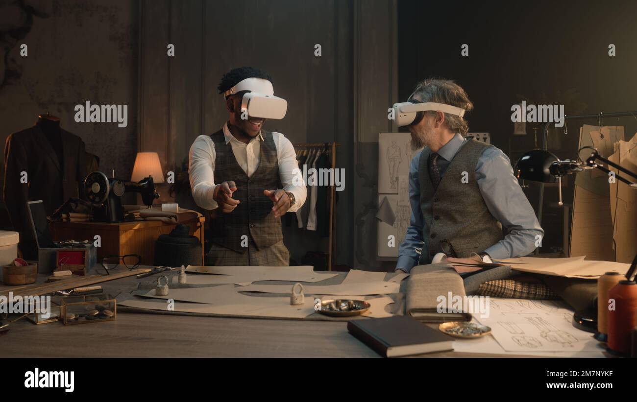 Multi ethnic tailors wearing VR headset with wireless controllers. They ...