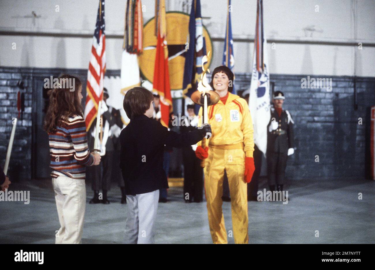 First Olympic torchbearer Sandy Norris, after her relay, lights ...