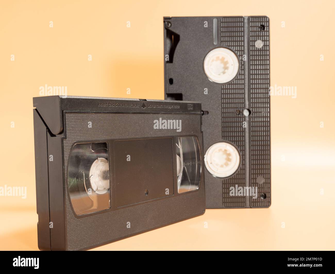Old VHS cassettes on an orange background. Retro video cassettes. Close ...