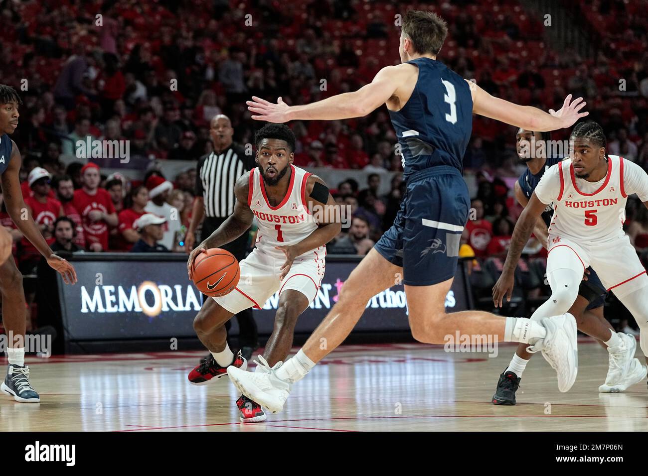 Houston guard Jamal Shead (1) drives on North Florida forward Carter ...
