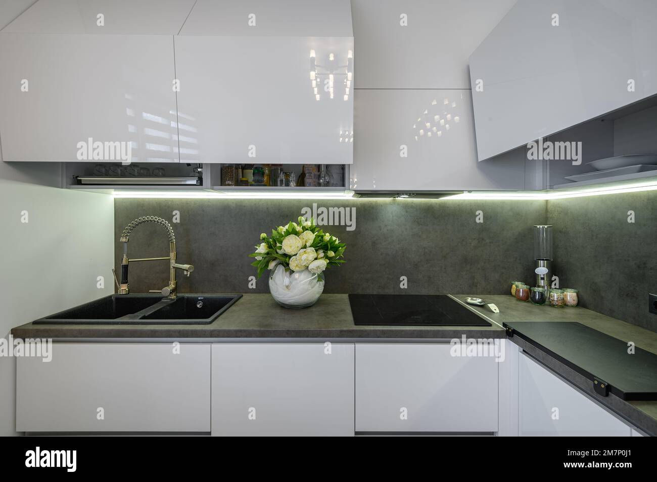 Dark grey counter counter top at white trendy kitchen Stock Photo - Alamy