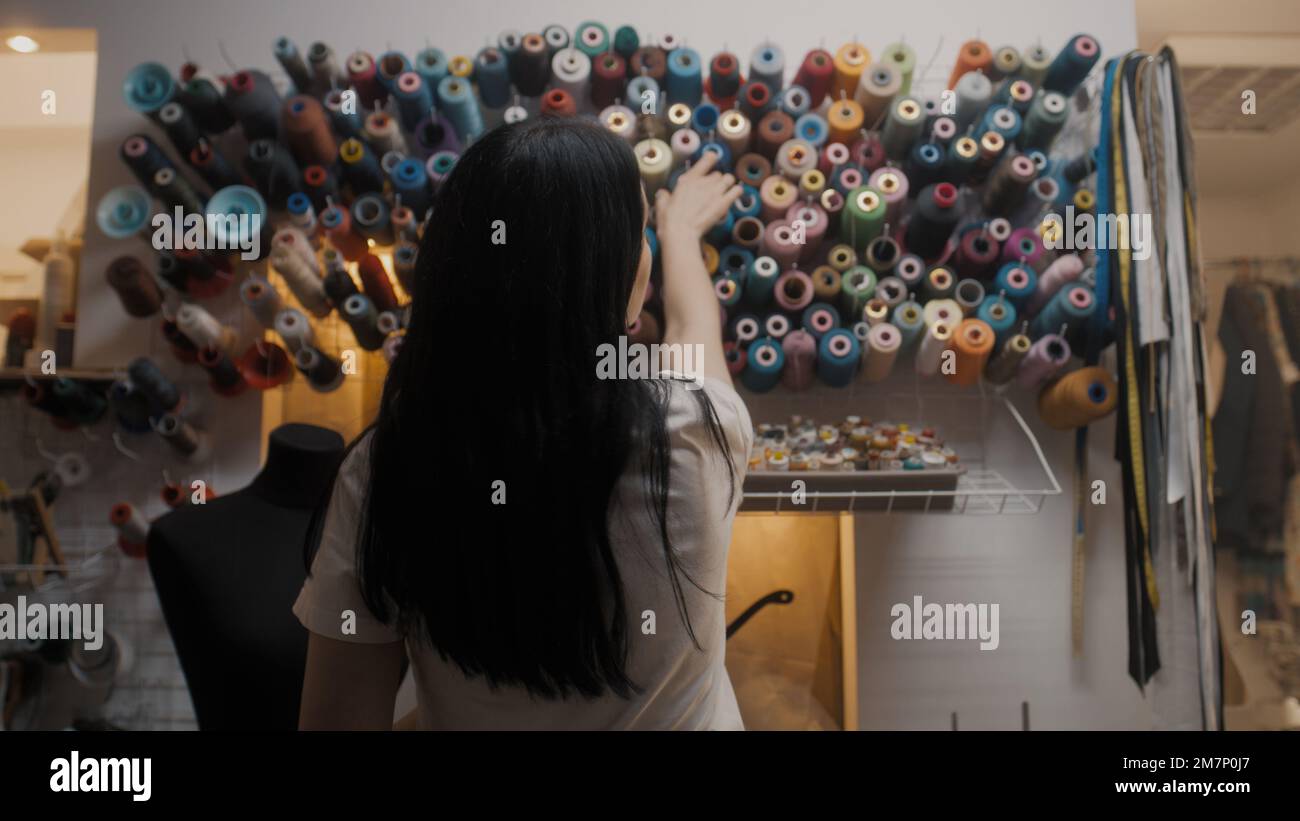 Fashion designer chooses color of threads for tailoring new wedding ...