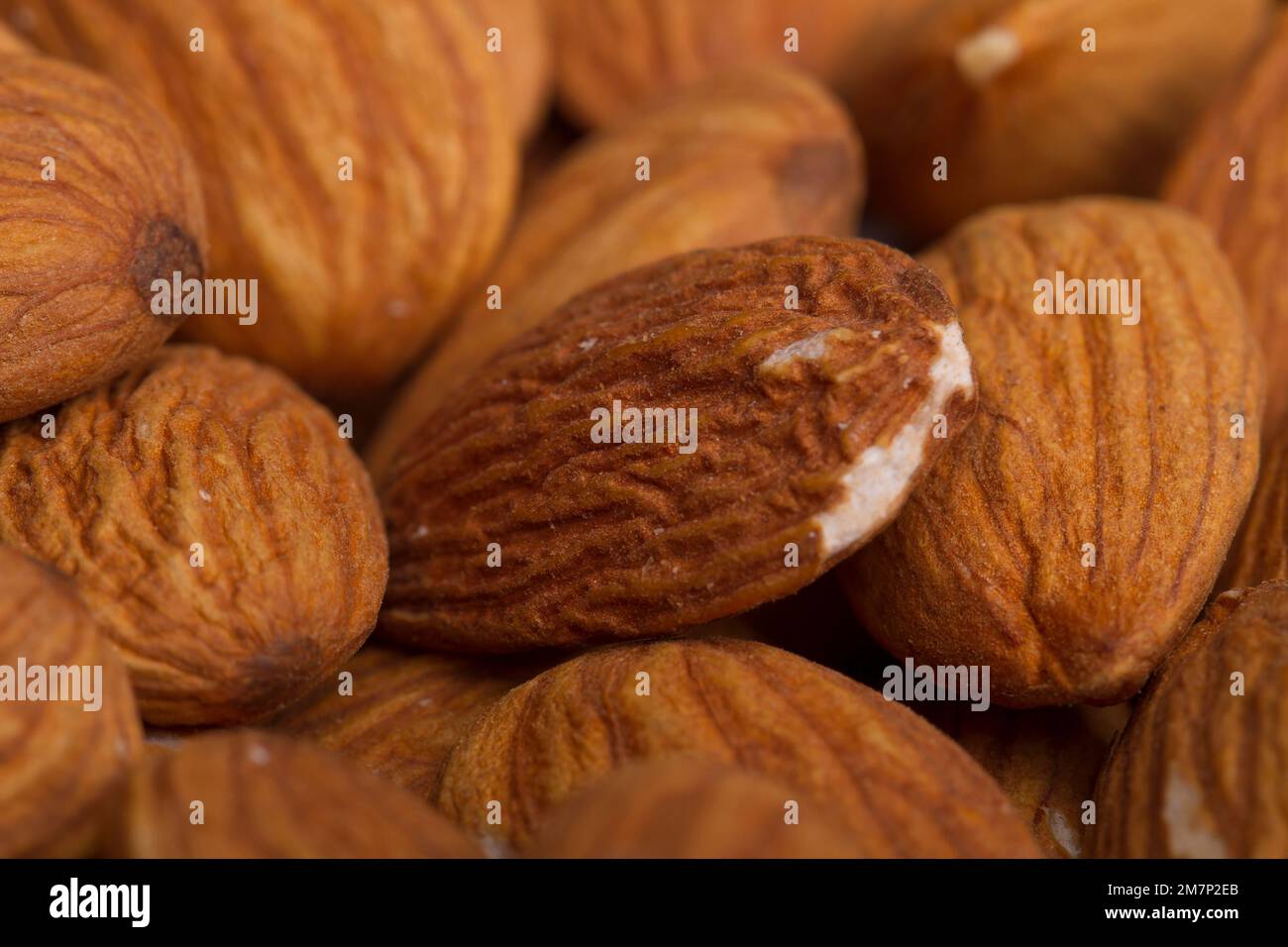 Close up on almonds resting on a flat background Stock Photo - Alamy