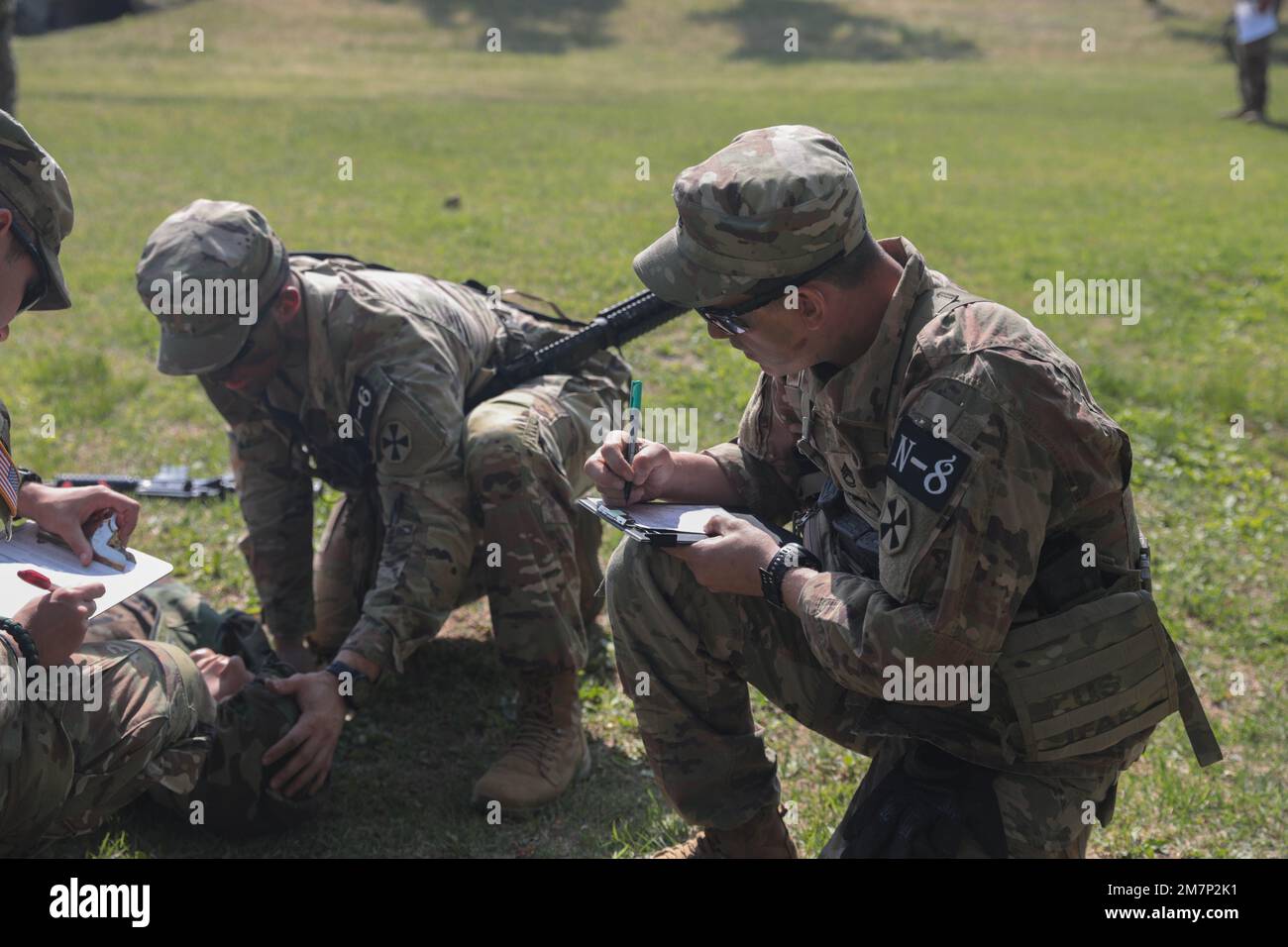 U.S. Army Sgt. 1st Class Phillip Cox (right) fills out a Tactical ...