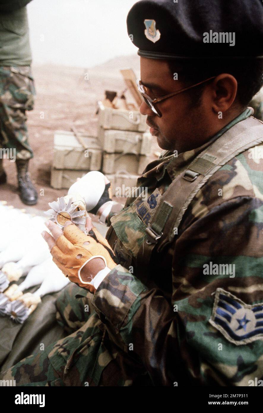 Security policeman SSGT Michael Moore sets a charge on an illumination ...