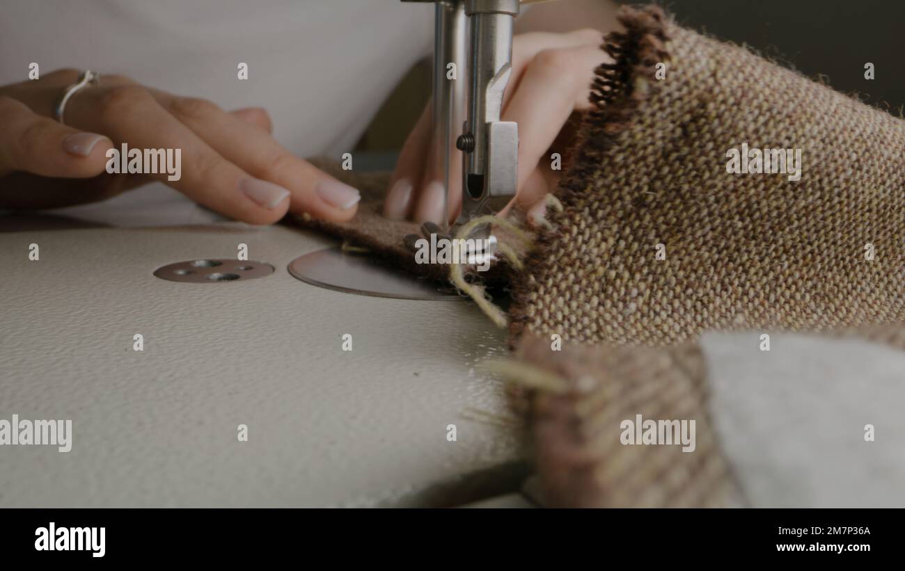 Hands of female seamstress works on sewing machine. Designer sews ...