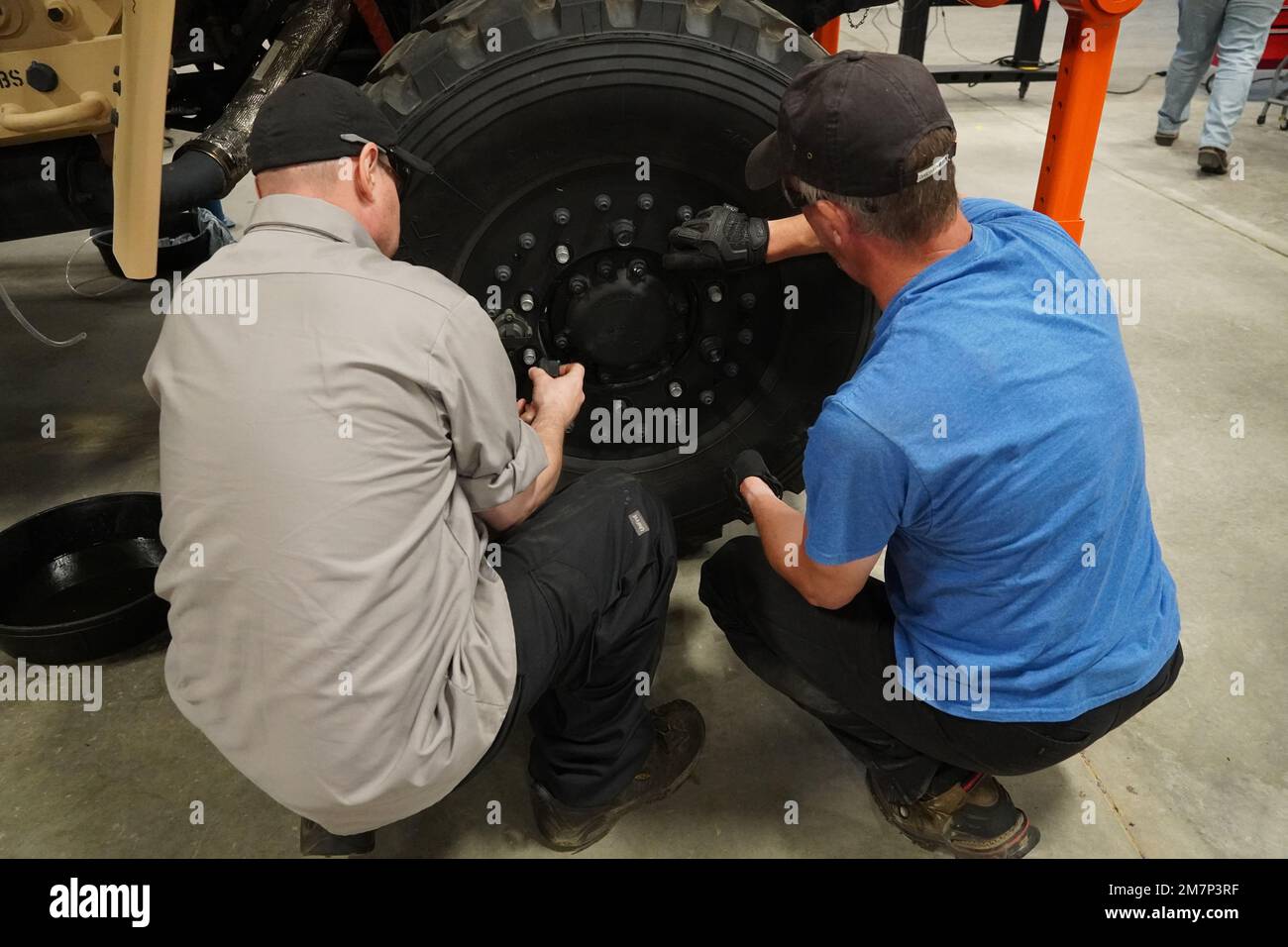 Students in the JLTV Phase II course install tire lug nuts. (Army photo ...
