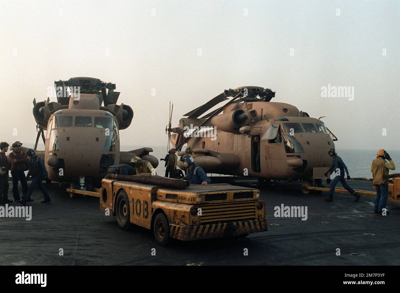 Tow tractors move two RH-53 Sea Stallion helicopters into position on ...