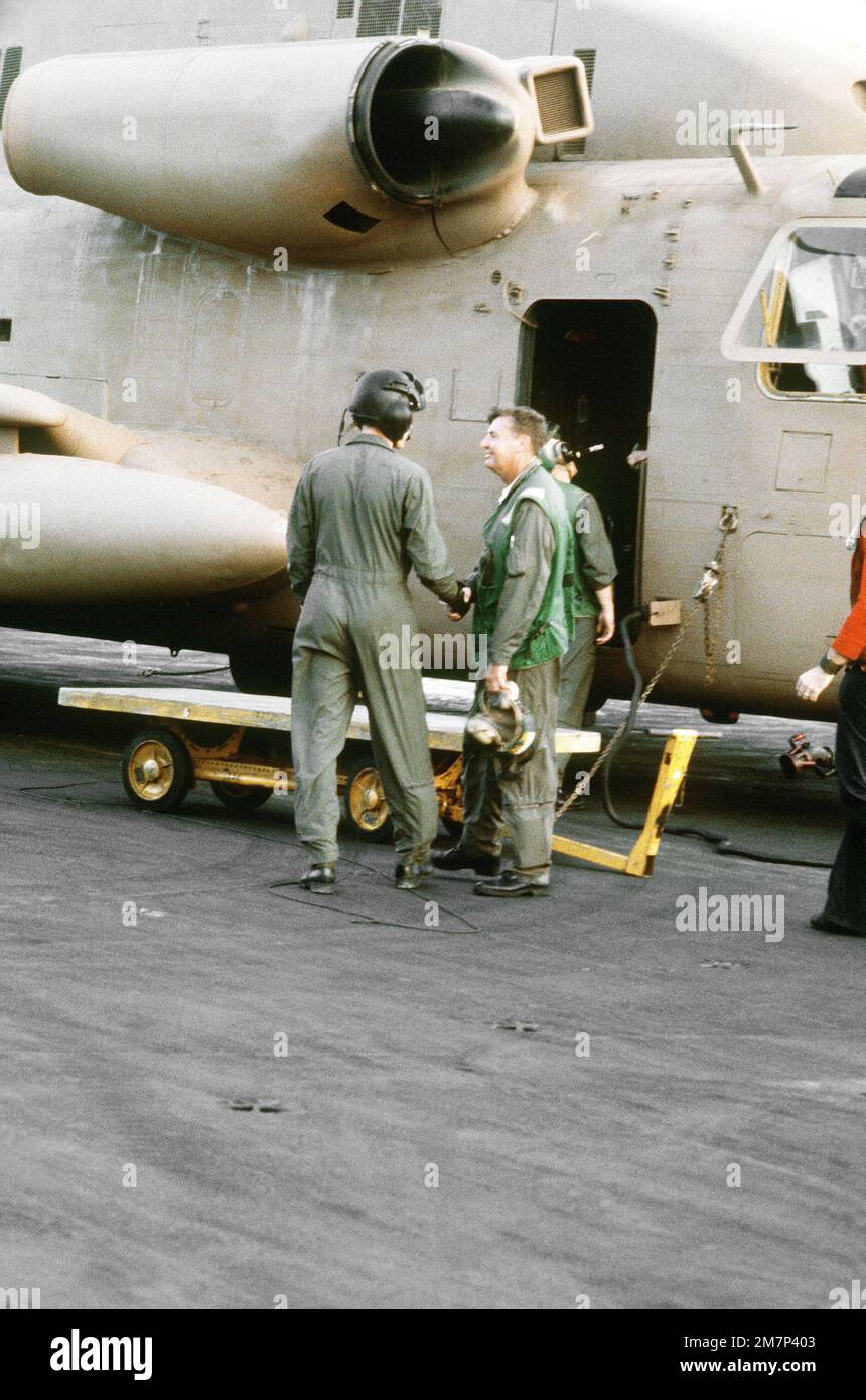 Crewmen board an RH-53 Sea Stallion helicopter on the flight deck of ...
