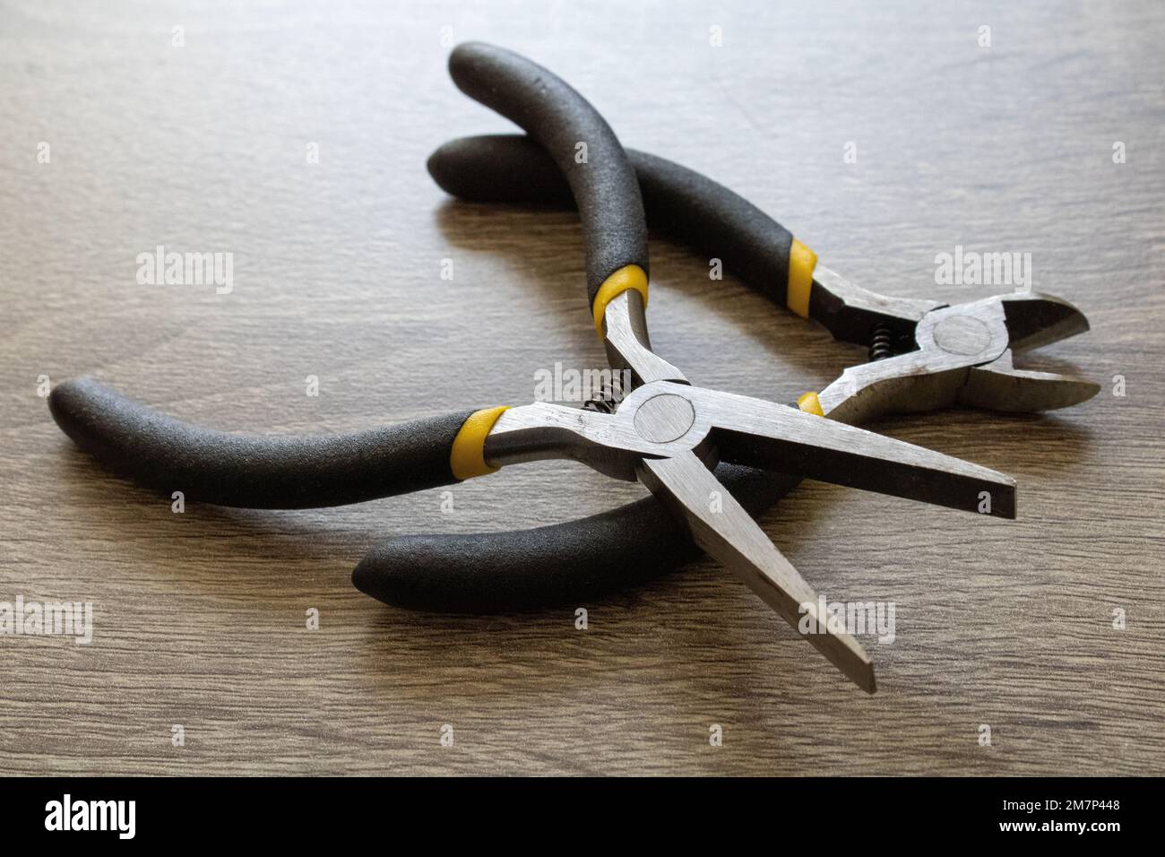 A closeup of flat nose pliers and wire cutter pliers on a table Stock ...