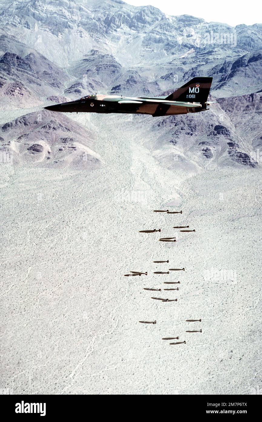An aerial left side view of an F-111 aircraft dropping 24 Mark 82 low ...