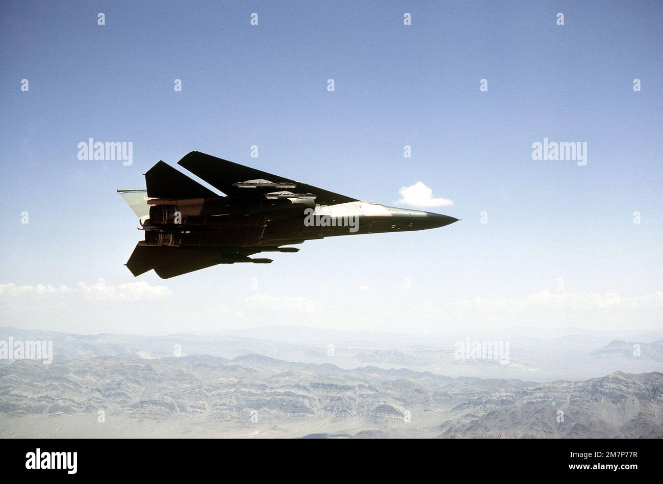 AN air-to-air right side view of an F-111A banking to the left over a ...