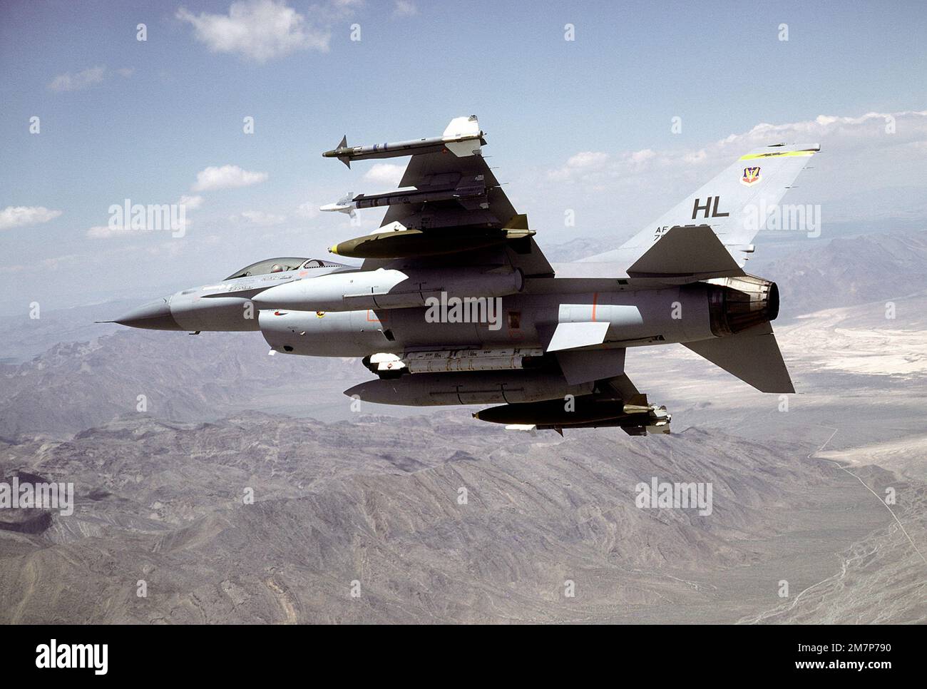 A left underside rear view of an F-16 Fighting Falcon aircraft banking ...