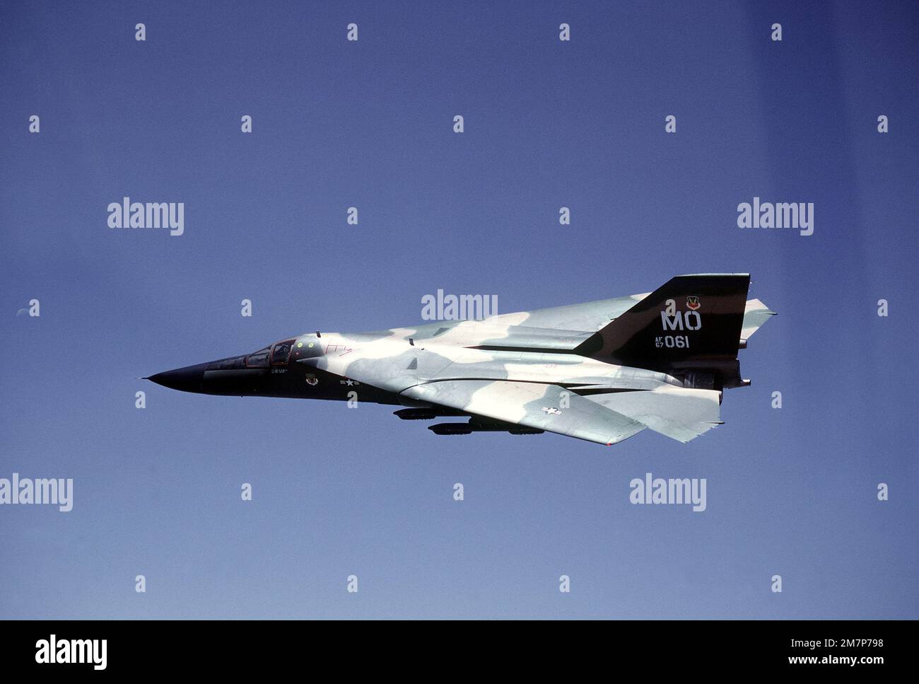 AN air-to-air left side view of an F-111A aircraft banking to the right ...