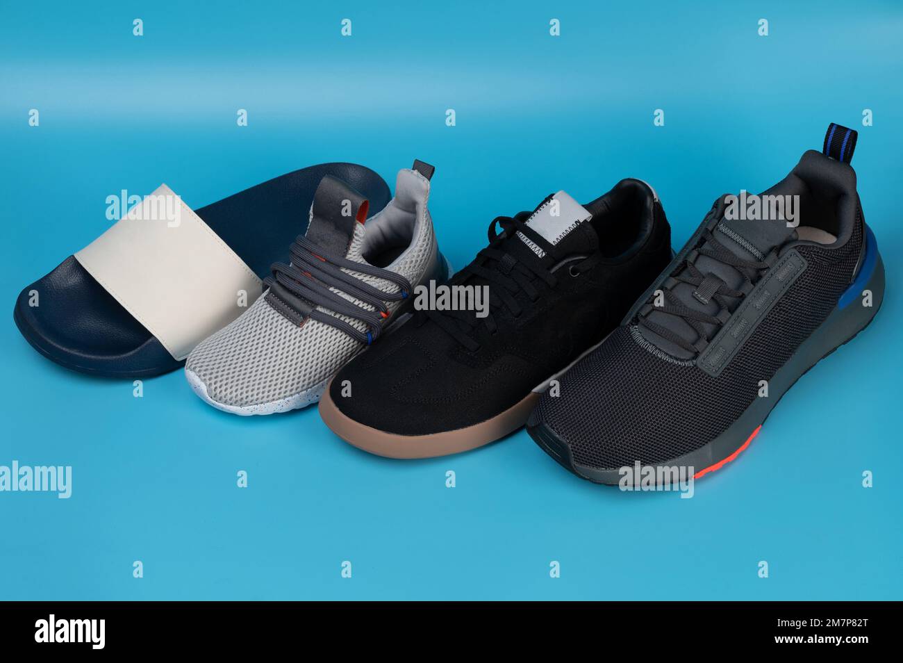 Pile of different shoes perspective view isolated on blue studio ...