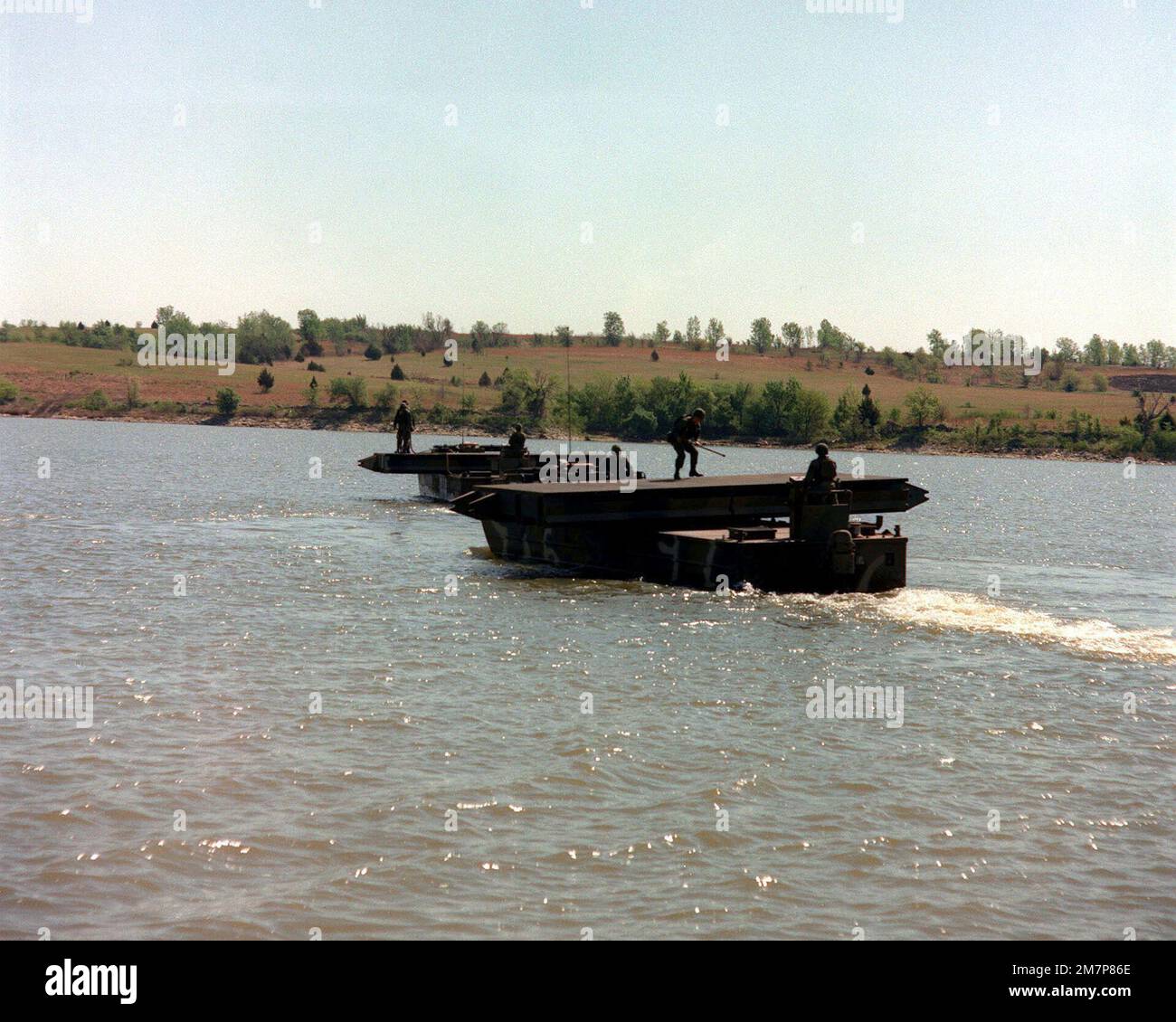 Sections of a mobile assault bridge are moved into position by members ...