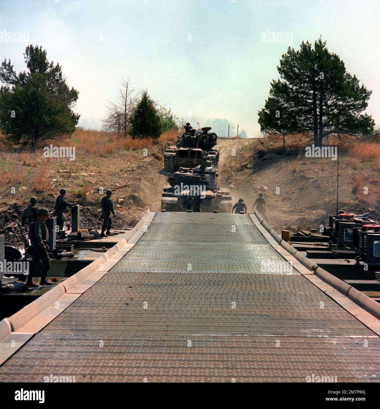 Tanks from the 2nd Brigade roll off a mobile assault bridge during a ...