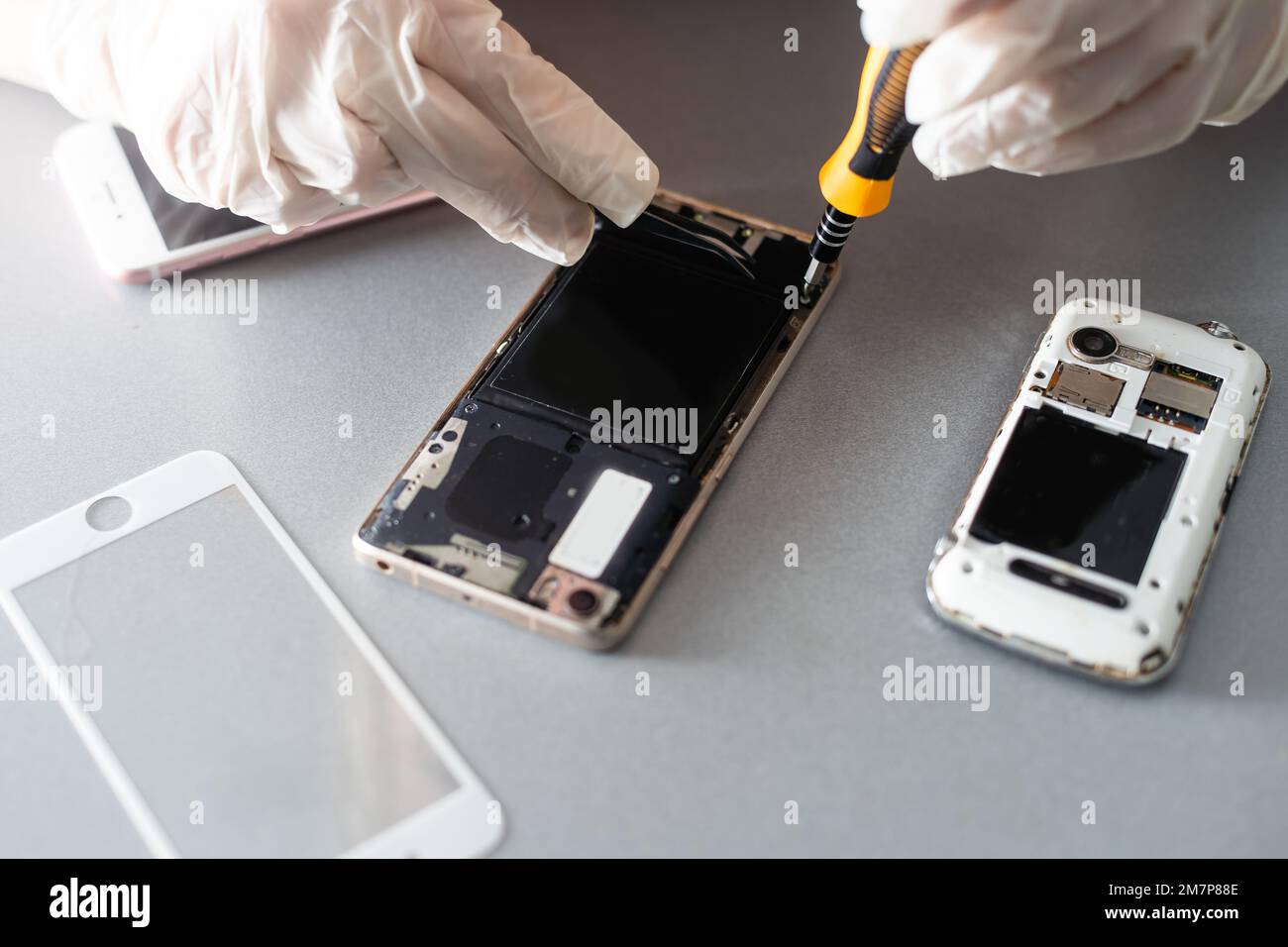 The technician repairing the smartphone's motherboard in the lab with ...