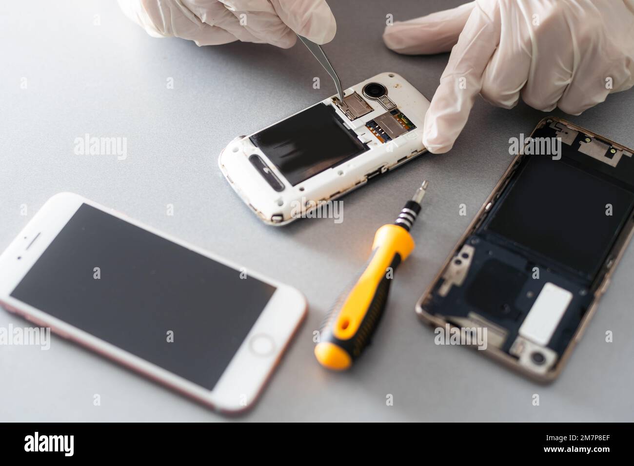 The technician repairing the smartphone's motherboard in the lab with ...