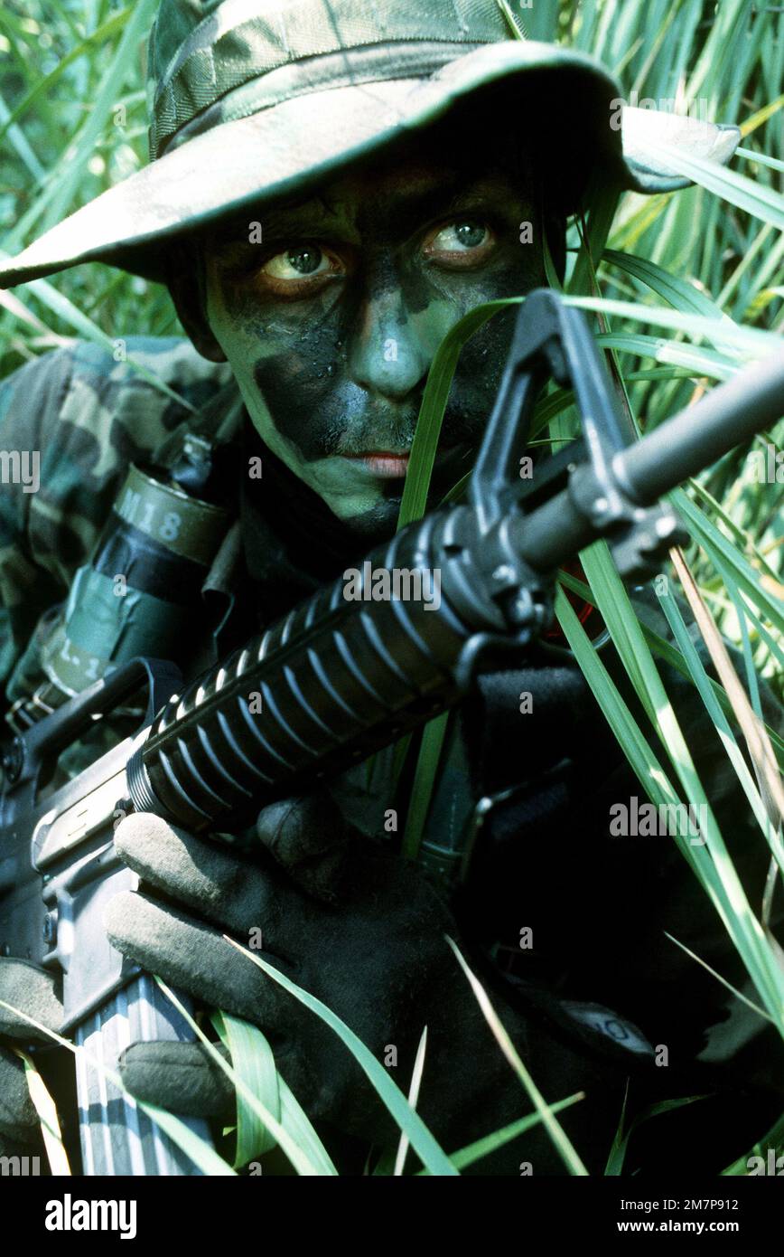 MSGT Wayne Fisk, wearing camouflage facial make-up, demonstrates combat ...
