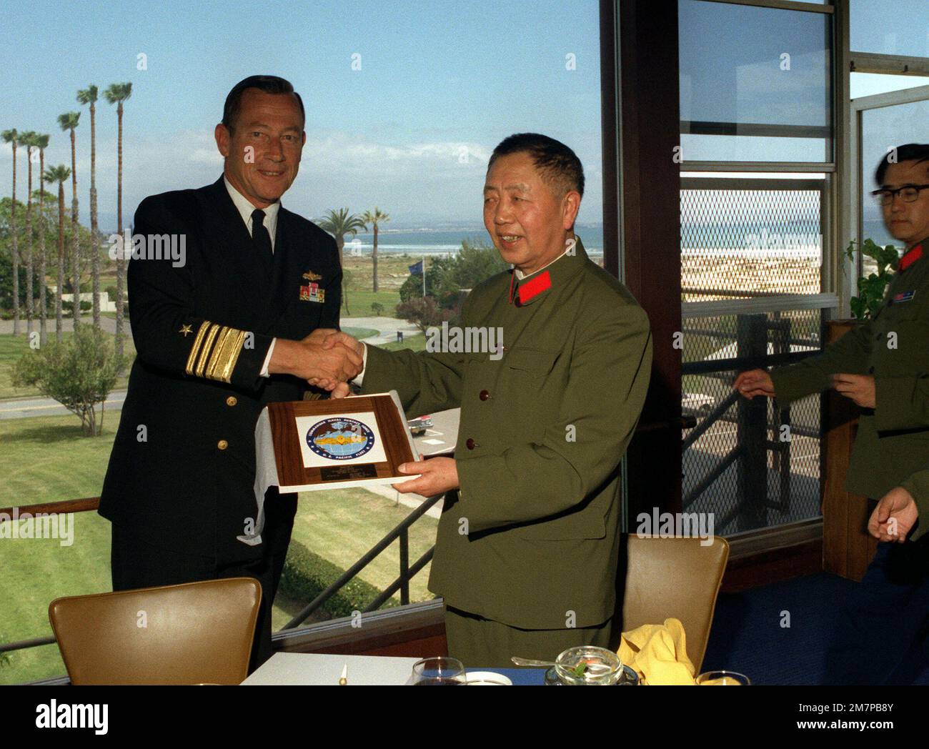 A member of the delegation from China is presented a plaque by VADM Lee ...