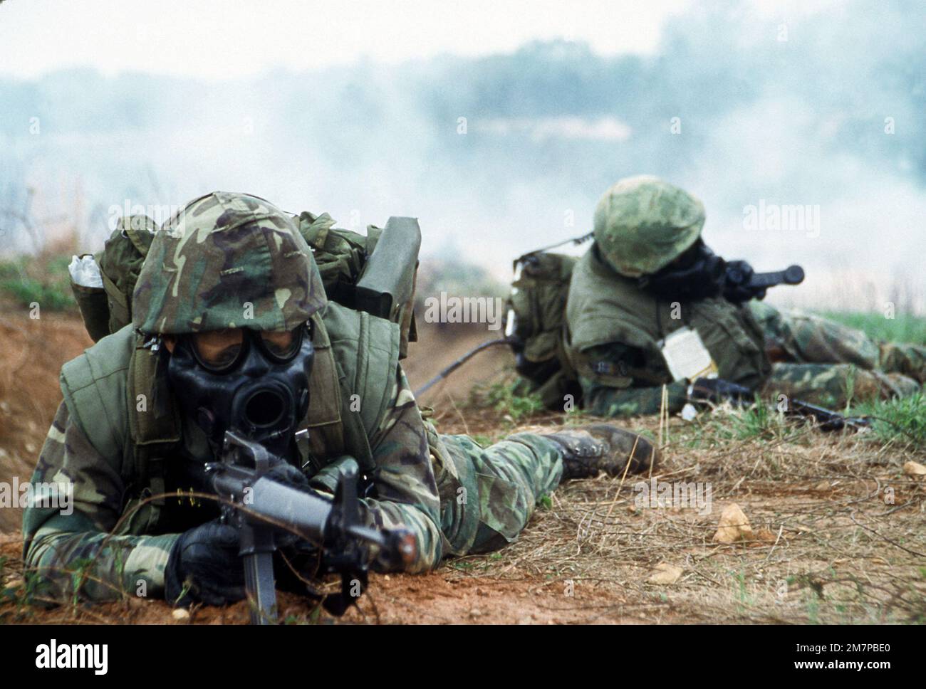 Marine officers, wearing chemical warfare gear and armed with M-16A1 ...