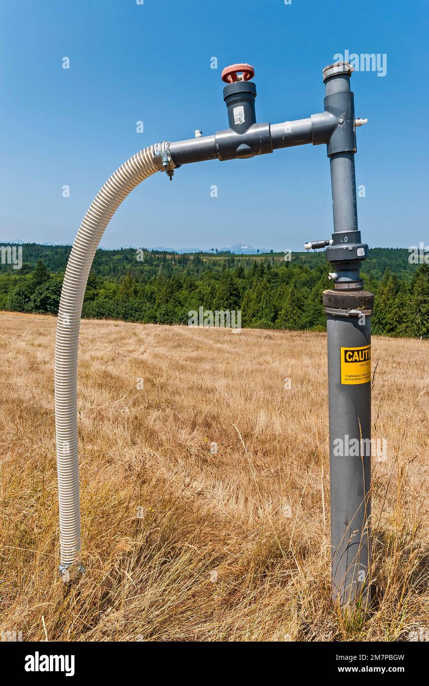 A vertical landfill methane gas wellhead and valve at an active ...